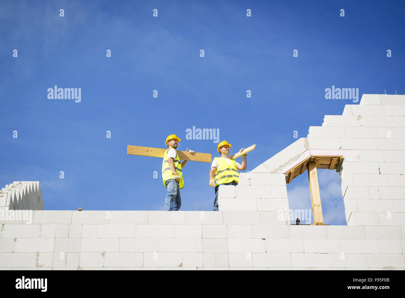 Builders are working on the top of house construction Stock Photo - Alamy