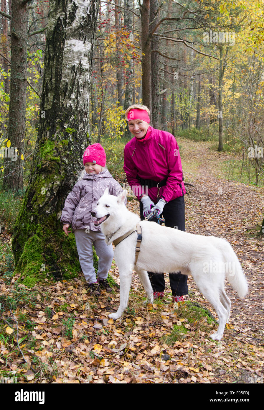 Granny with her granddaughter and a dog walk in autumn Park Stock Photo ...