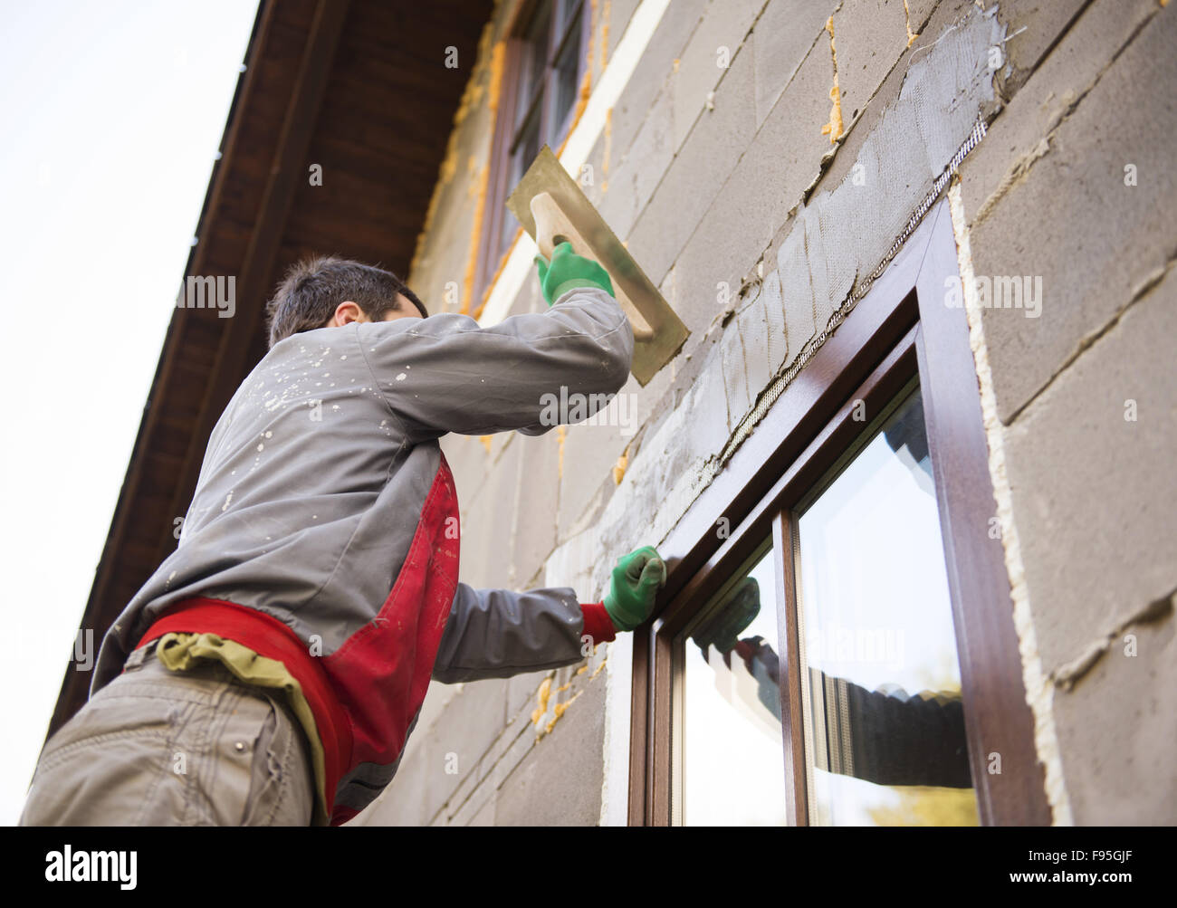 Plasterer spreading out plaster with trowel around the windows Stock ...