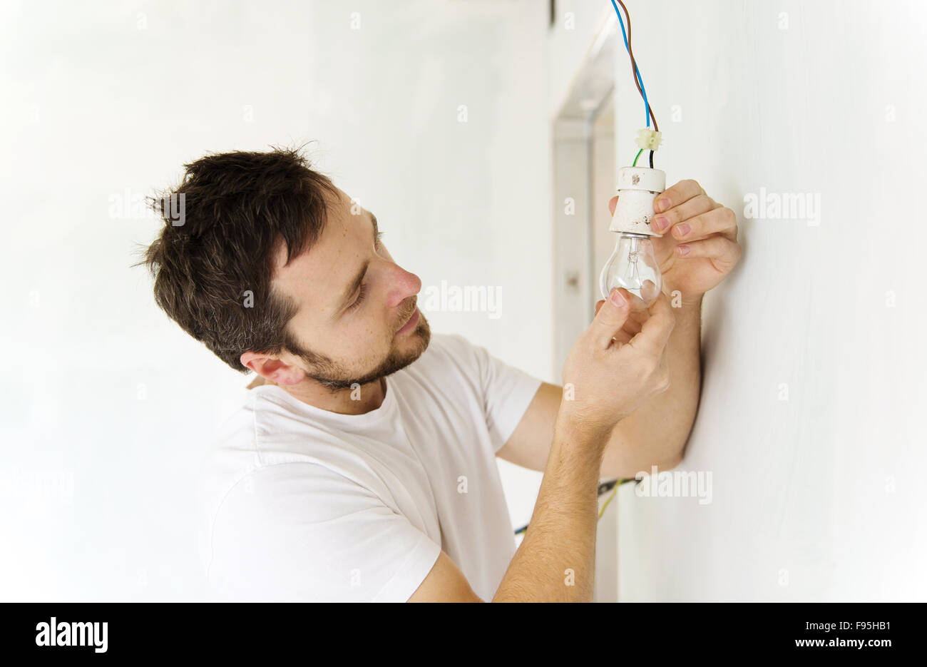 Electrician installing light in a new house Stock Photo - Alamy
