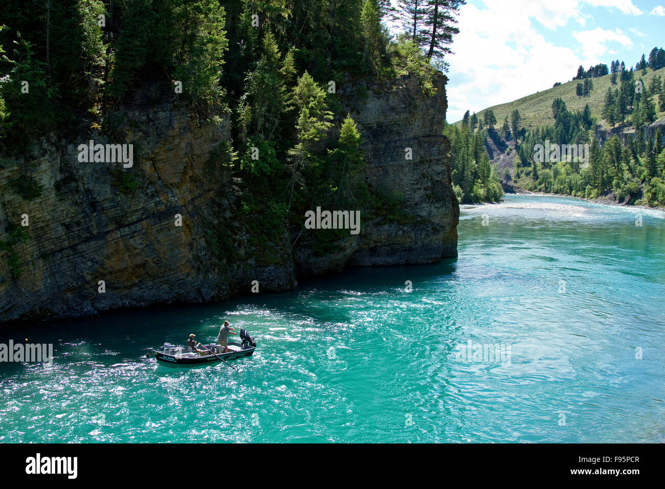 Middleaged man flyfishing on Bull river with guide rowing fishing boat ...