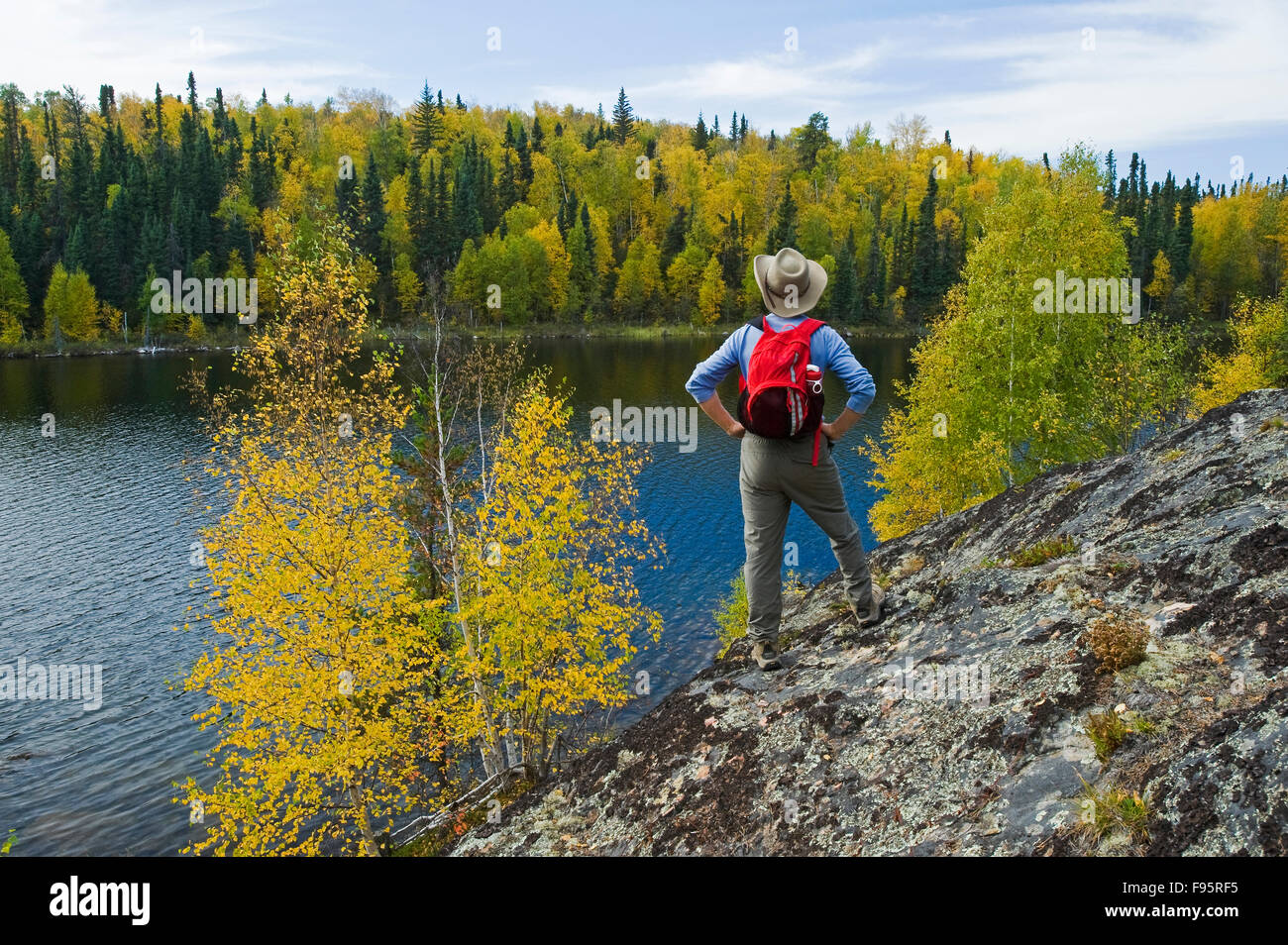 hiker on Precambrian shield rock, Dickens Lake, Northern Saskatchewan ...