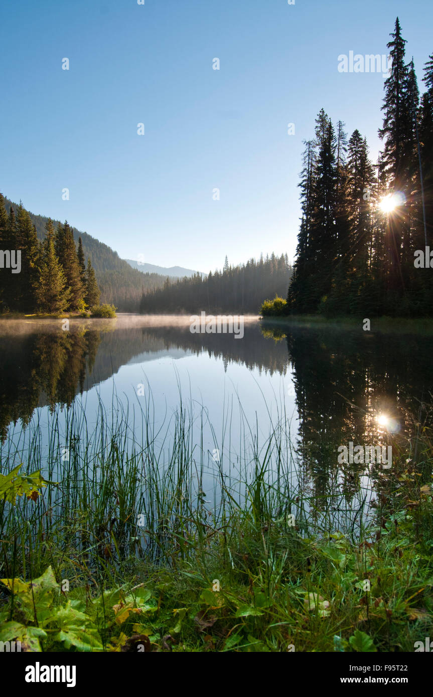 The late summer sun rises over Lightning Lake in Manning Park, BC and ...