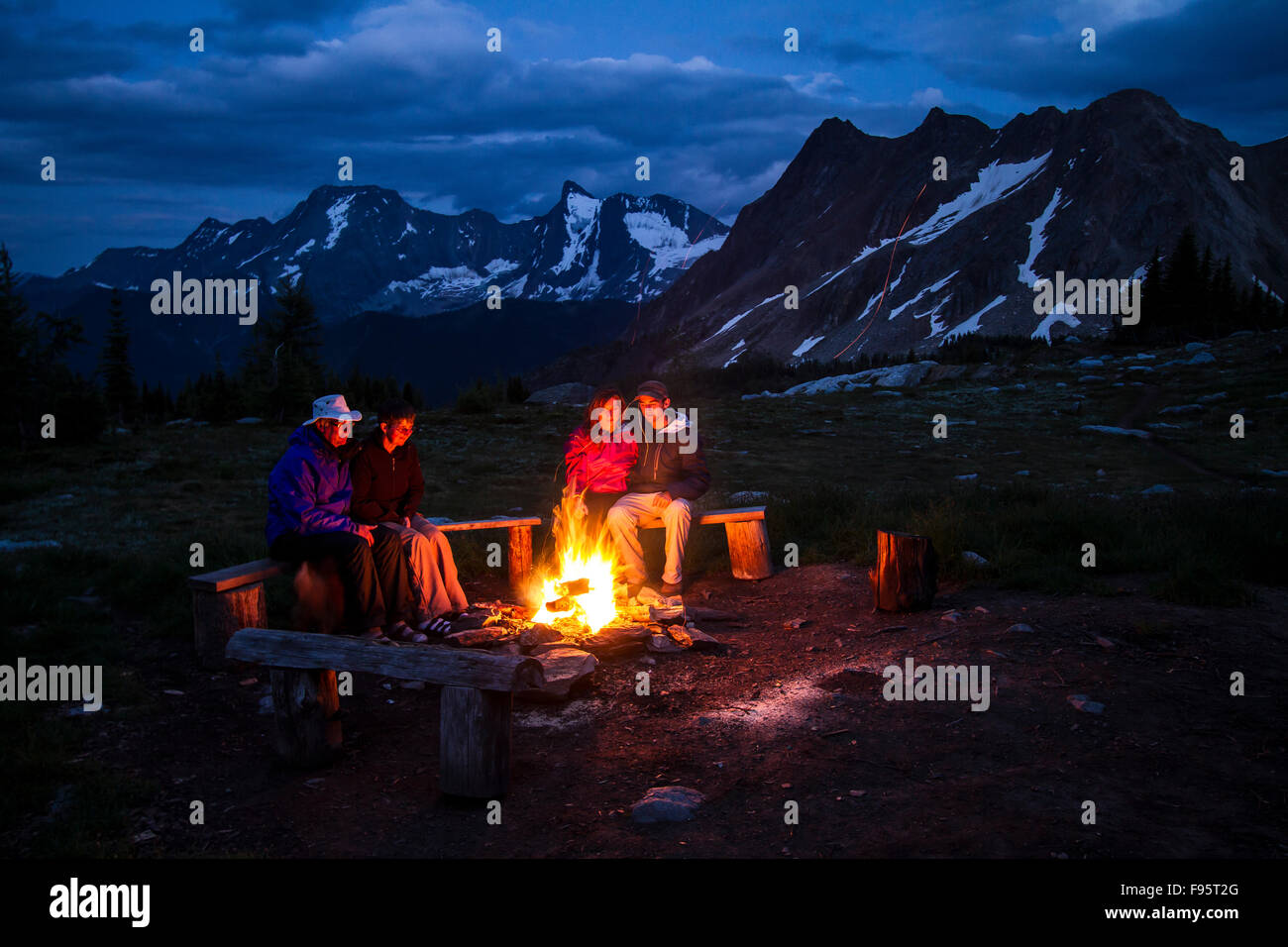 Two couples enjoying a campfire on Mount Earl Grey, Jumbo Pass, British ...