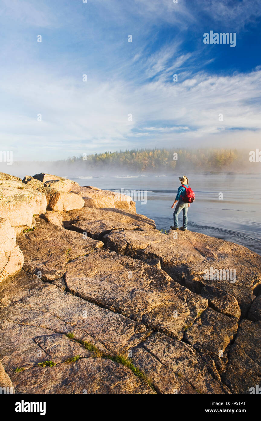 hiker on Canadian Shield rock, Namau Lake, Whiteshell Provincial Park ...