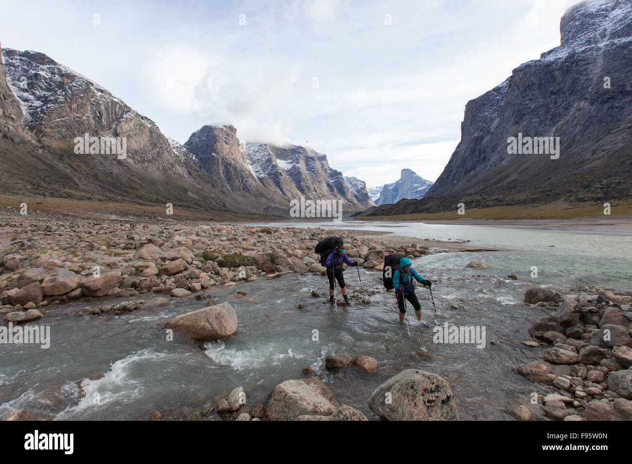 Hikers cross a creek in Auyuittuq National Park, Nunavut, Canada Stock ...