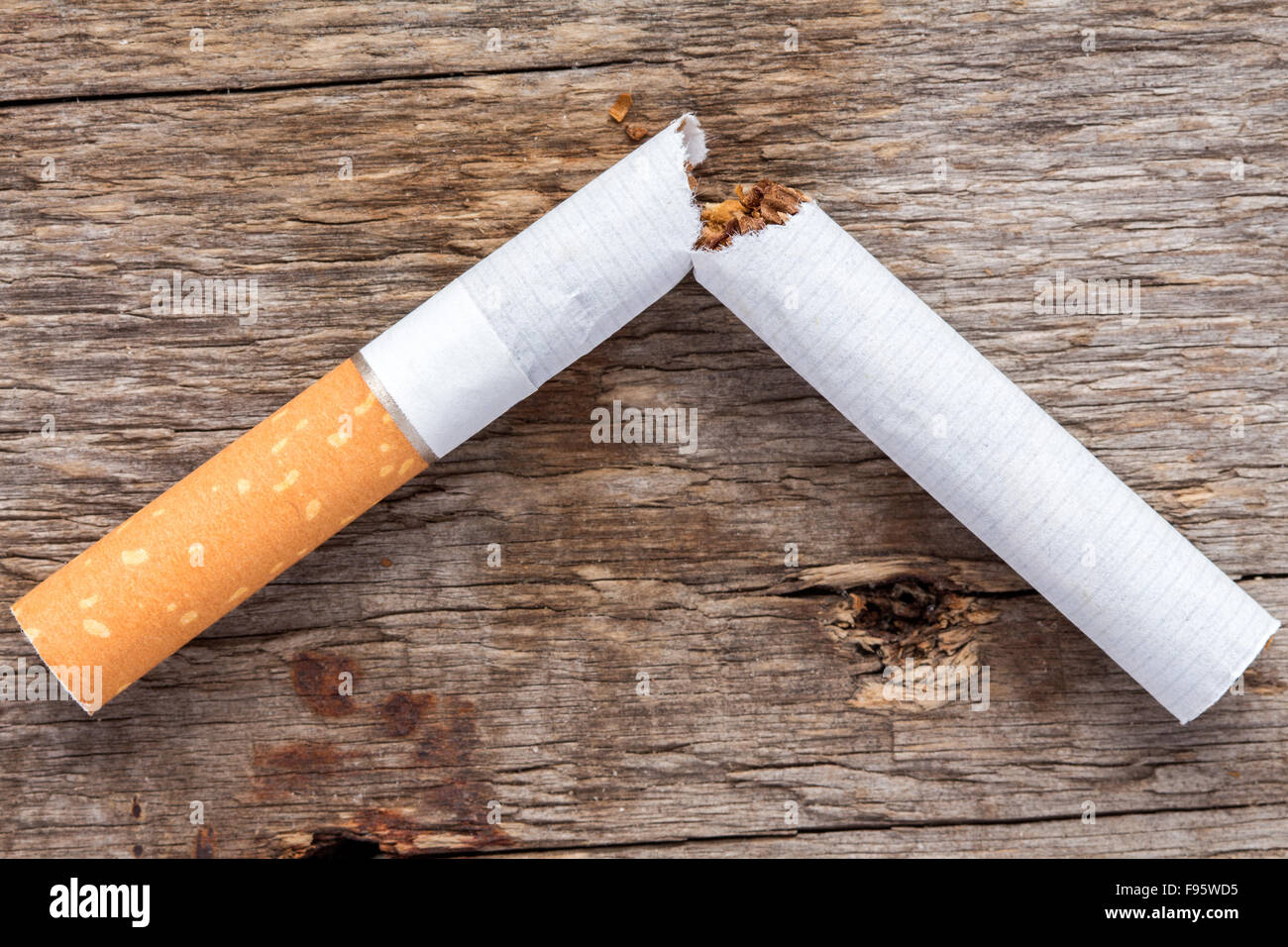 Close-up of broken cigarette on wooden background (Quit smoking today ...