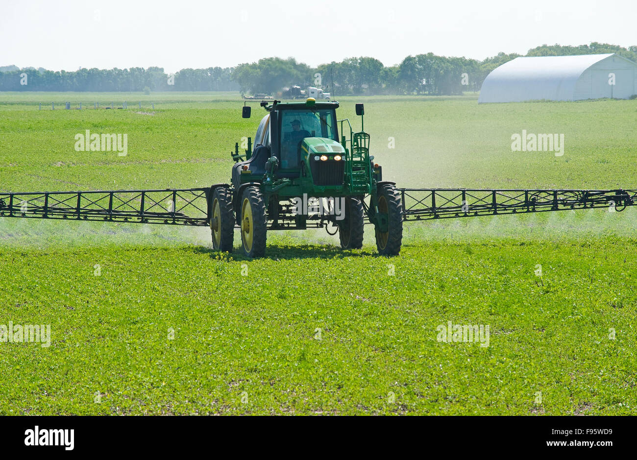 a high clearance sprayer gives a chemical application of herbicide to ...