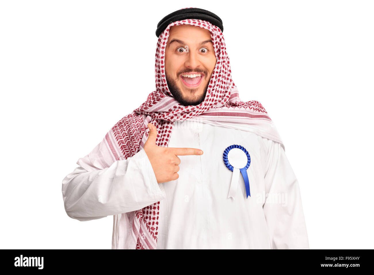 Joyful young Arab wearing an award ribbon on his robe and pointing ...