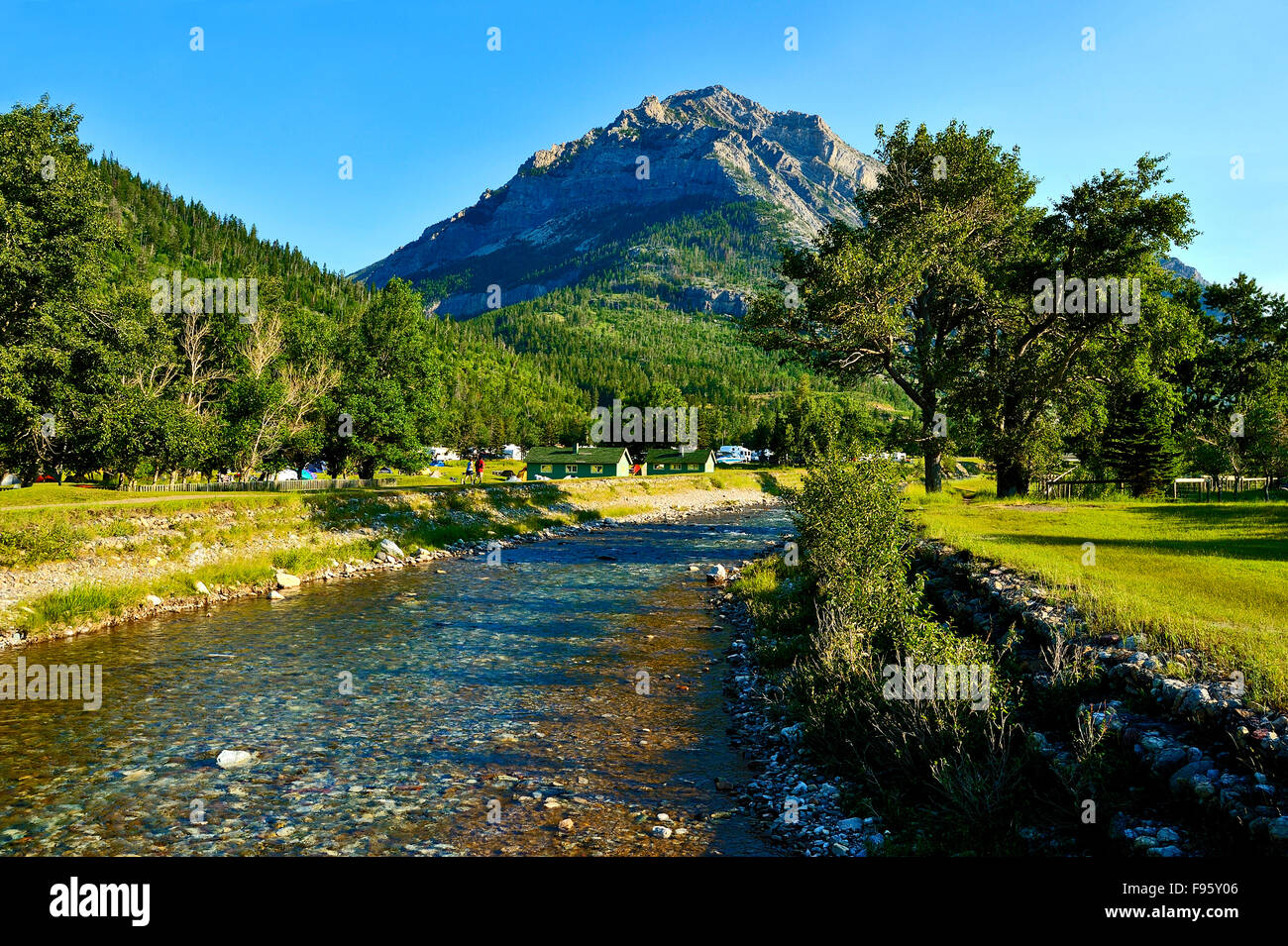 A summer landscape image of a slow moving stream and mountain in ...