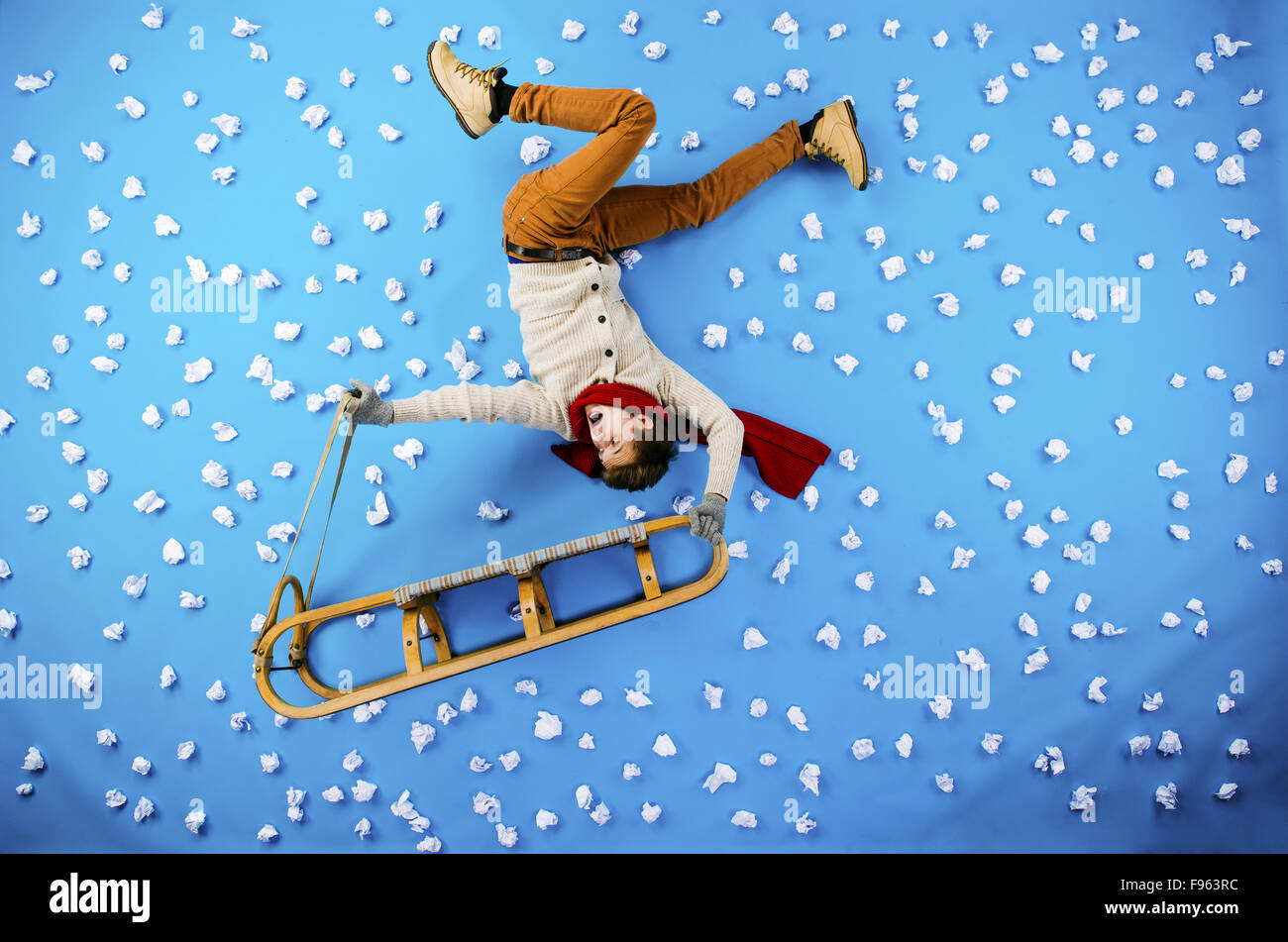 Happy young man on sled having fun against the blue background with ...