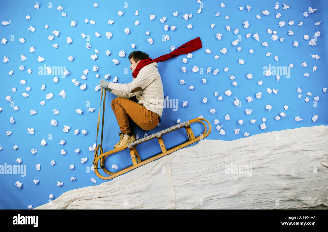 Happy young man on sled having fun against the blue background with ...