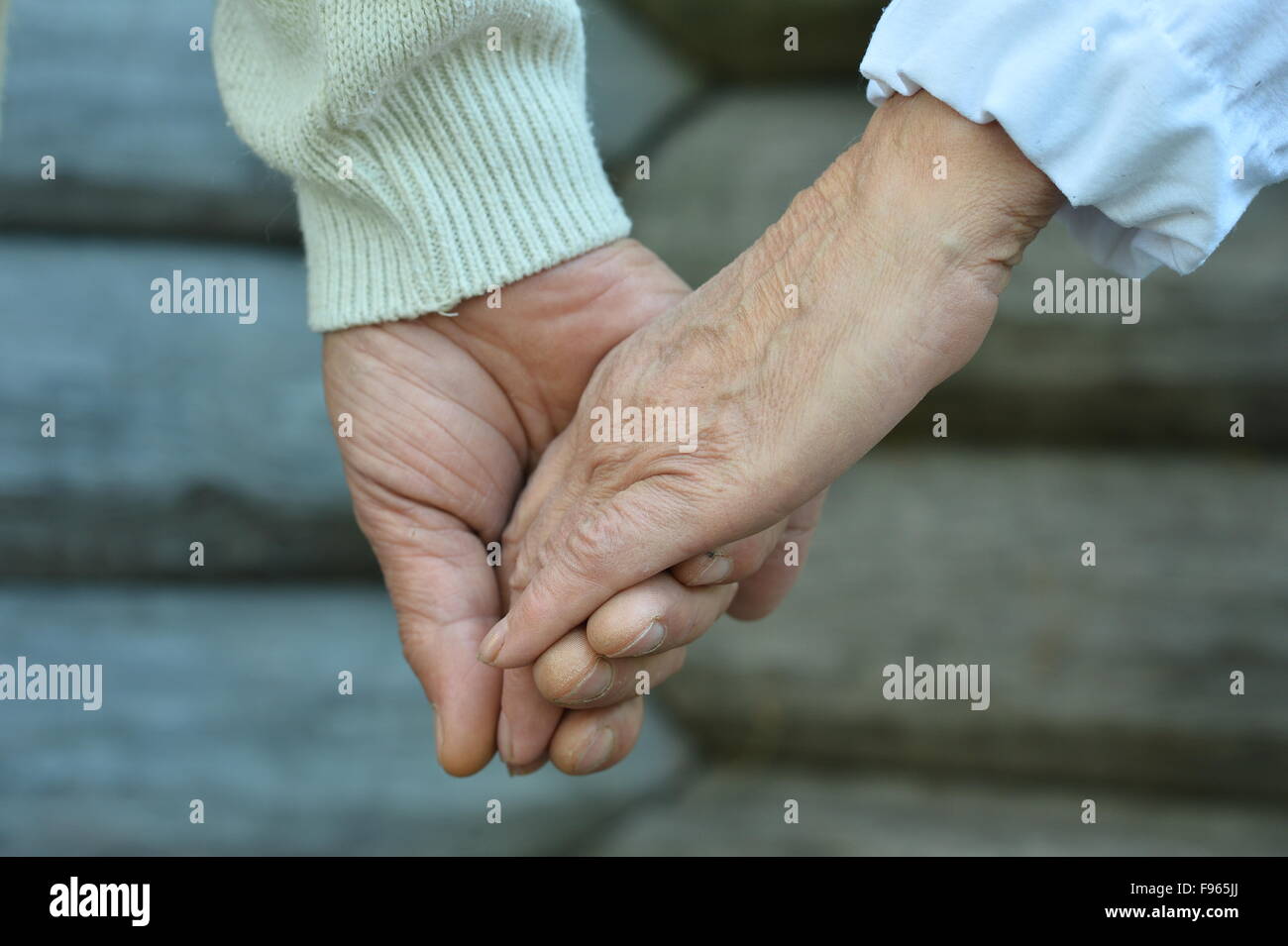 Elderly couple holding hands Stock Photo - Alamy