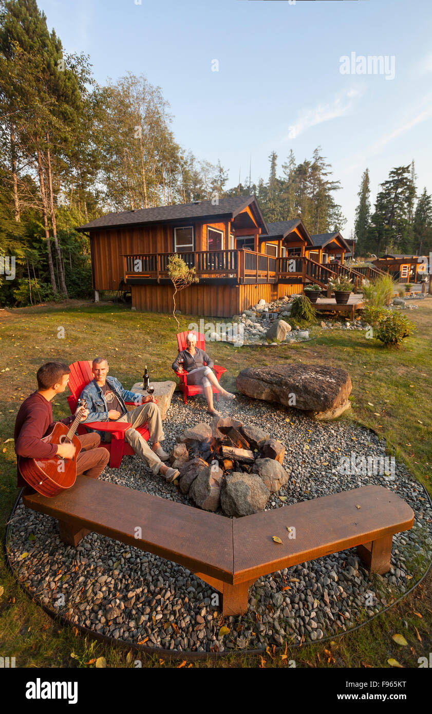 Friends gather around a fire while staying at the Ecoscape Cabins ...