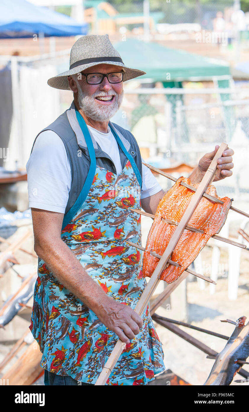 a volunteer cook prepares a freshly cooked Sockeye during Salmon Days ...