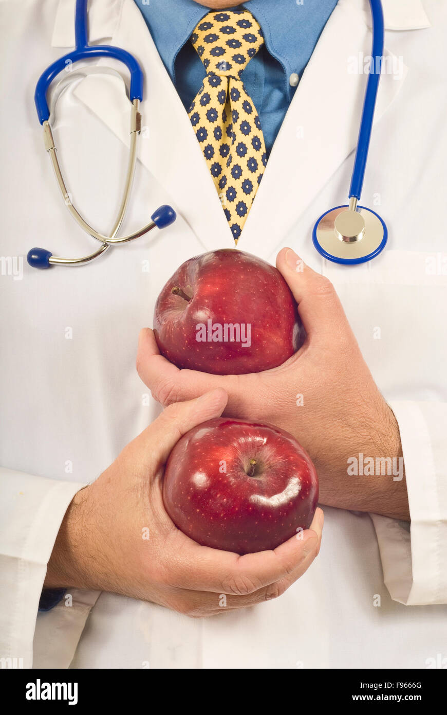 Doctor holding two red apples one above the other Stock Photo - Alamy
