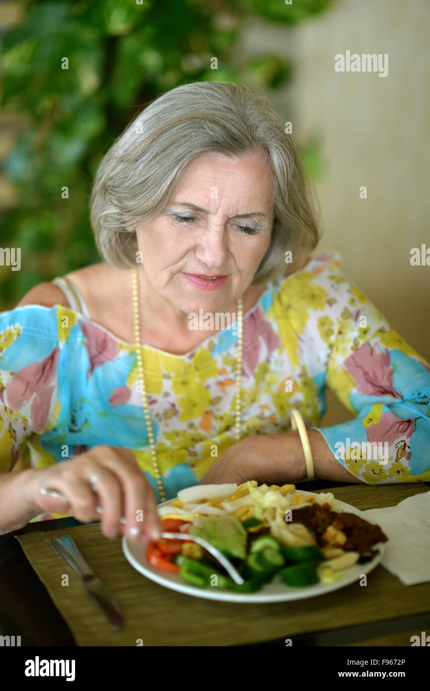 Senior woman eating breakfast Stock Photo - Alamy