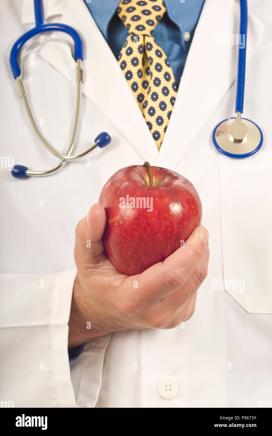 Male Doctor's hand holding one red apple Stock Photo - Alamy