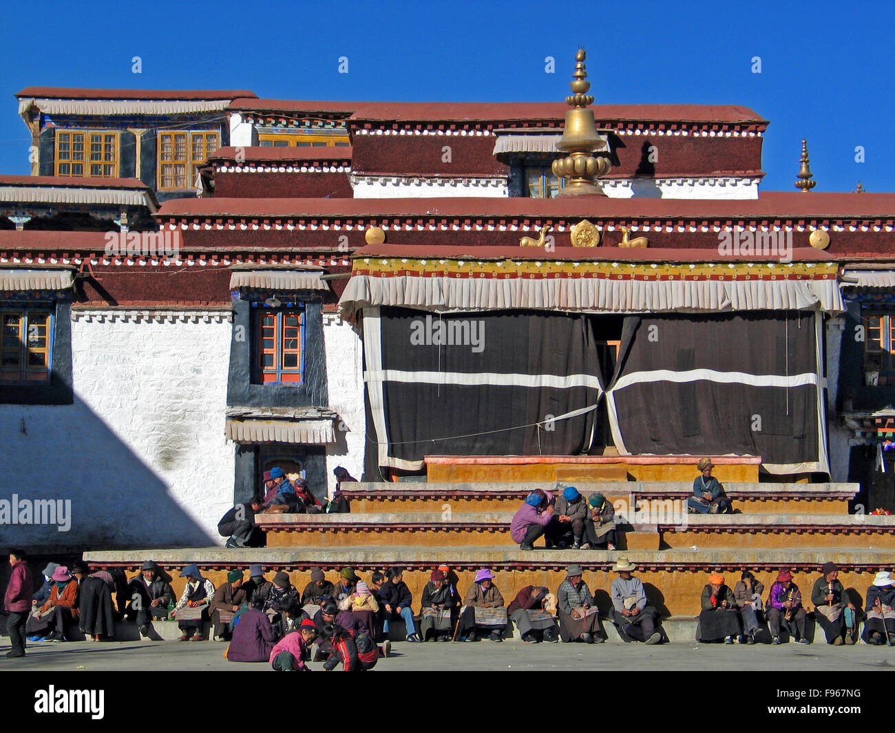 Tibetans sitting in the sun Stock Photo - Alamy