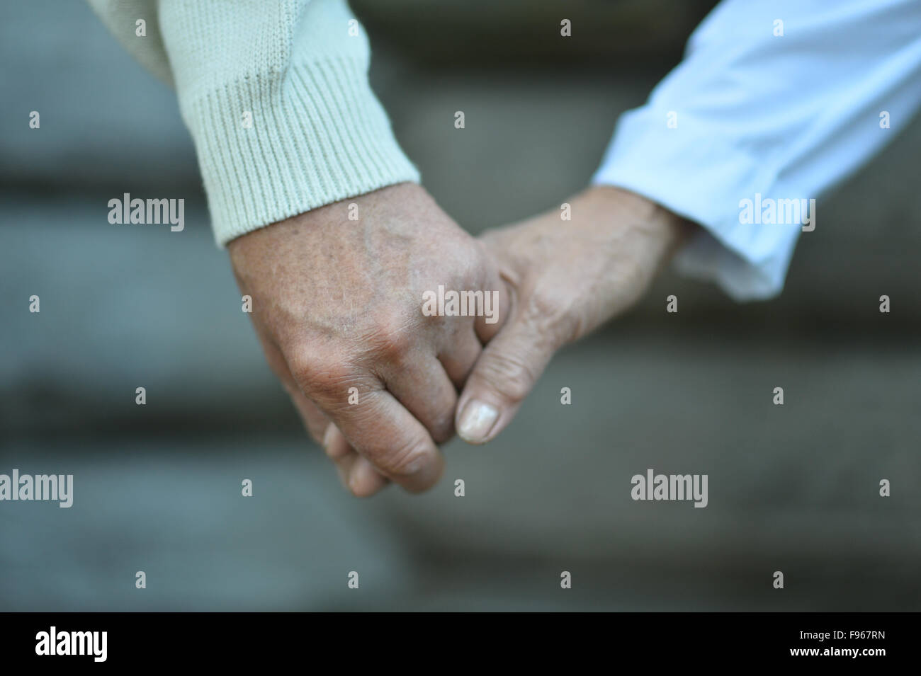 Elderly couple holding hands Stock Photo - Alamy