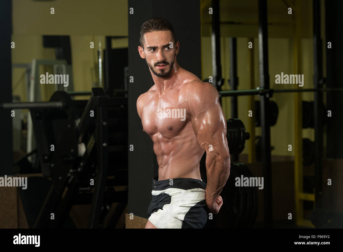 Serious Man Standing Strong In The Gym And Flexing Muscles Stock Photo ...