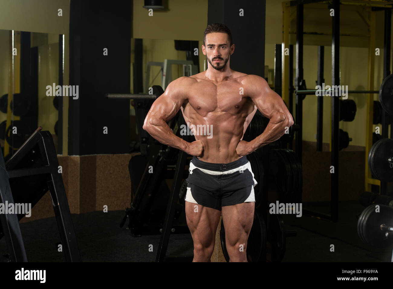 Serious Man Standing Strong In The Gym And Flexing Muscles Stock Photo ...
