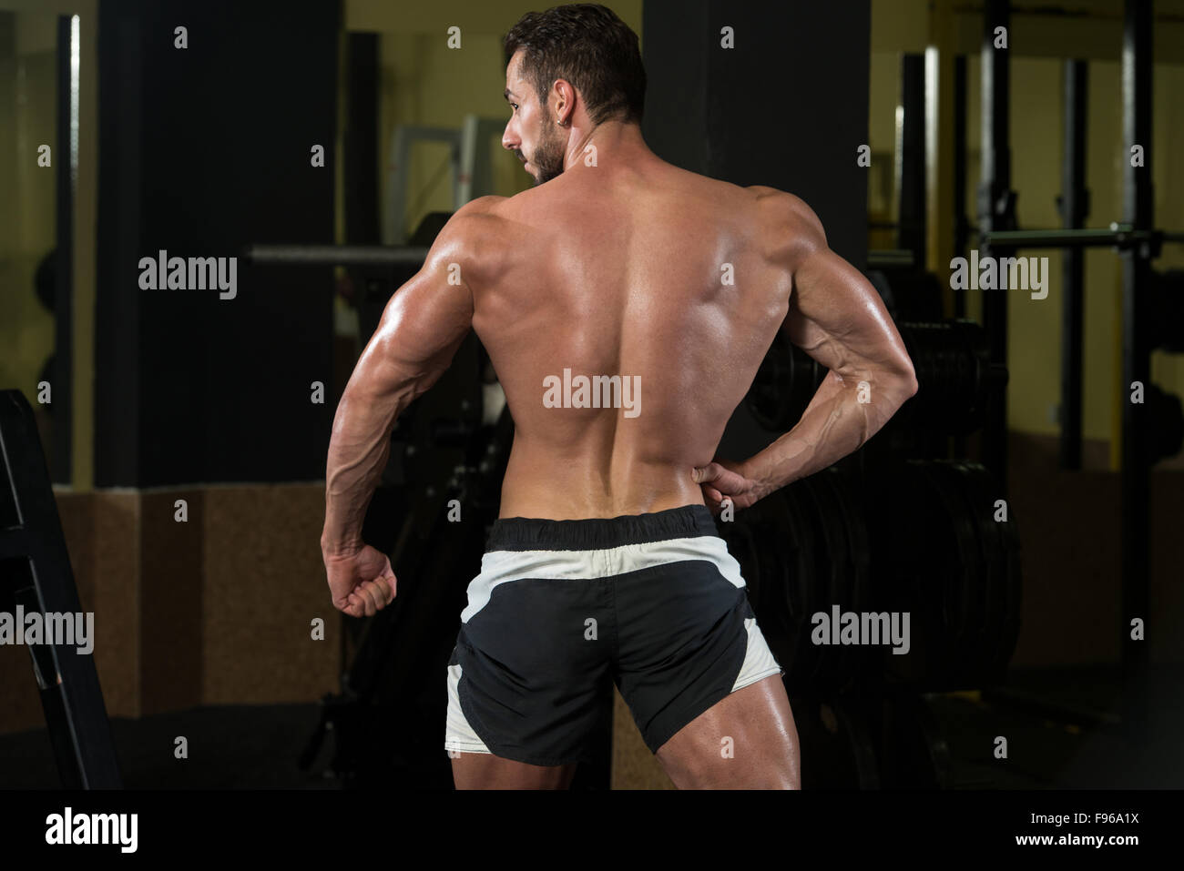 Serious Man Standing Strong In The Gym And Flexing Muscles Stock Photo ...