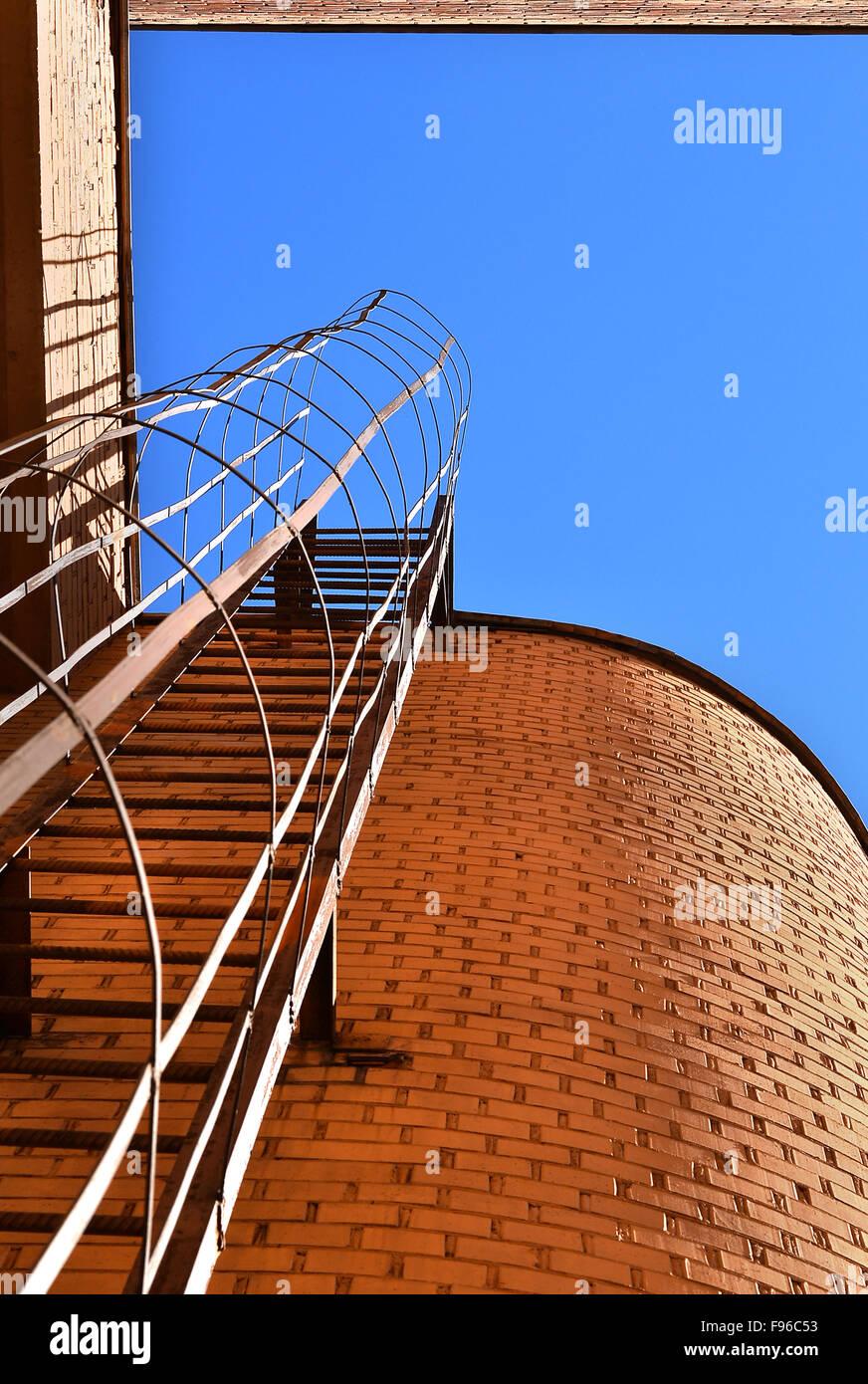 Industrial ladder, blue sky and brick walls of the building, bottom ...