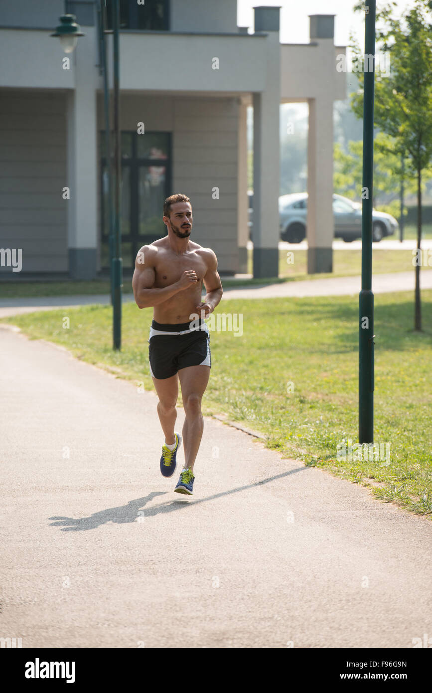 Young Bodybuilder Running In Park Area - Training And Exercising For ...