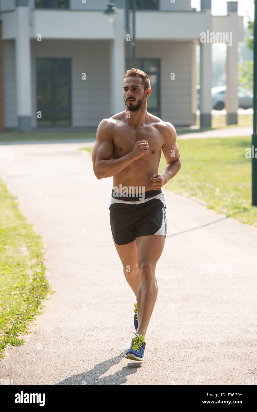 Young Bodybuilder Running In Park Area - Training And Exercising For ...