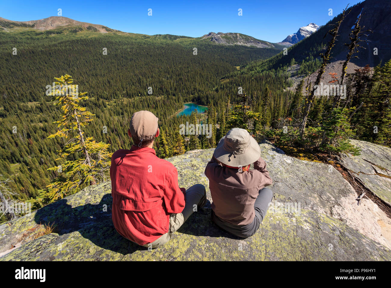 Two hikers rest at a viewpoint overlooking Egypt Lake in Banff National ...