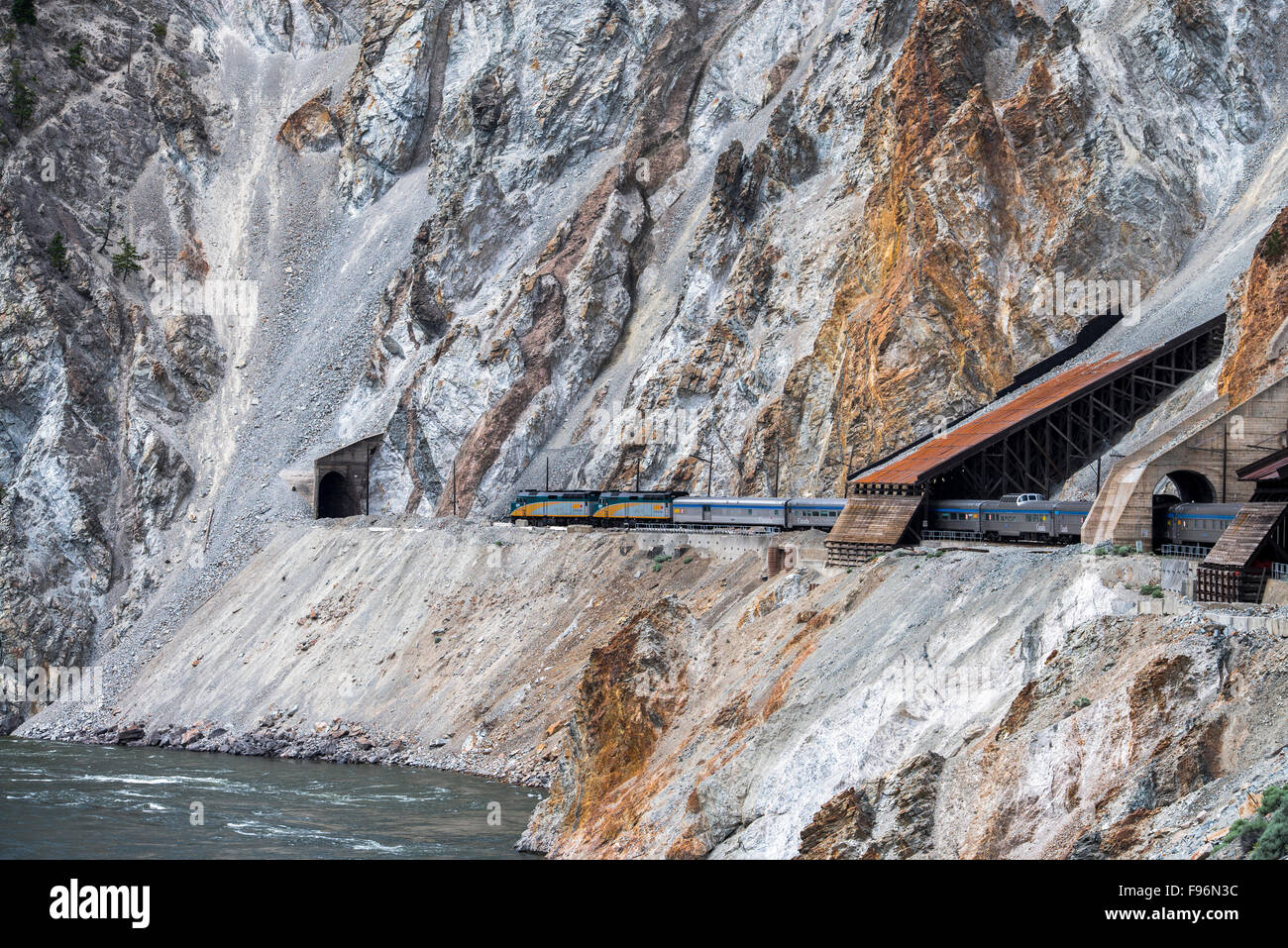Passenger train about to go through a tunnel in the Thompson River ...