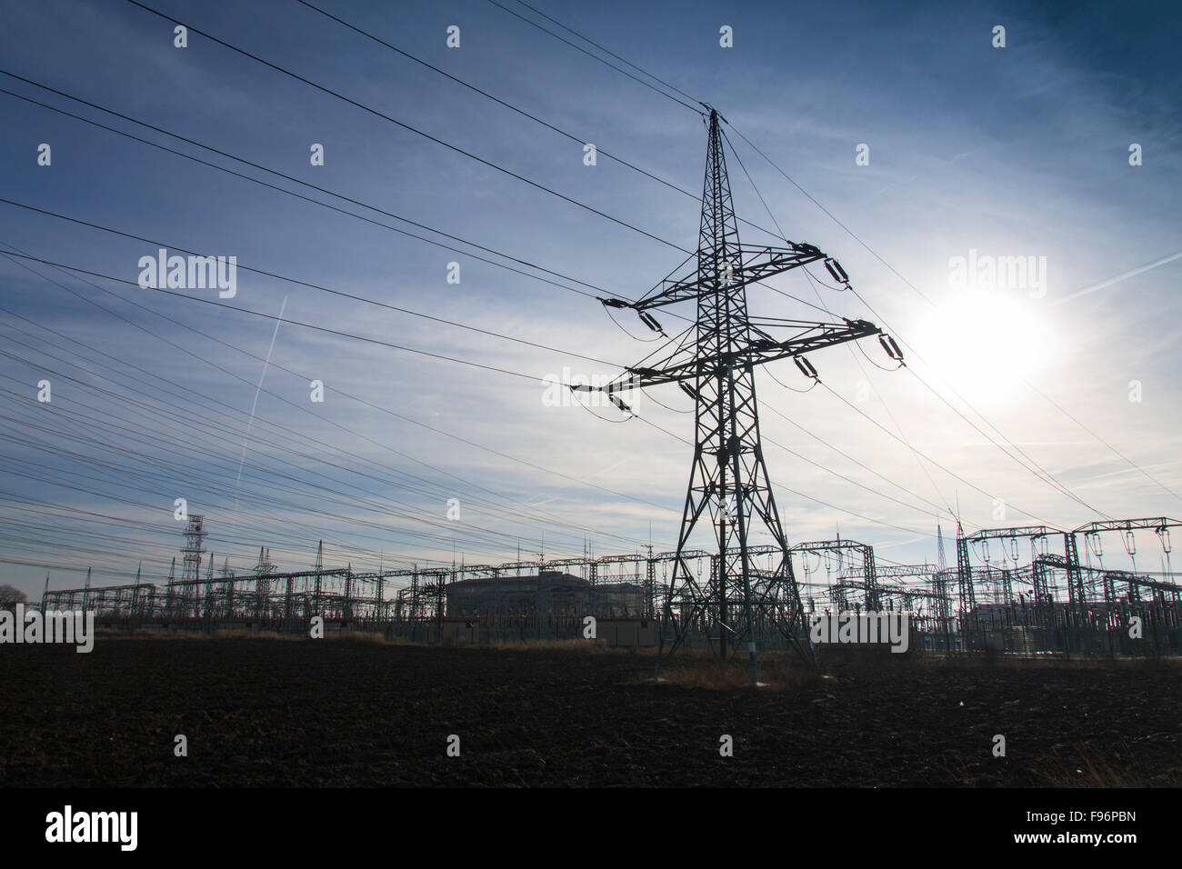Electricity pylon from distribution power station with sun in ...