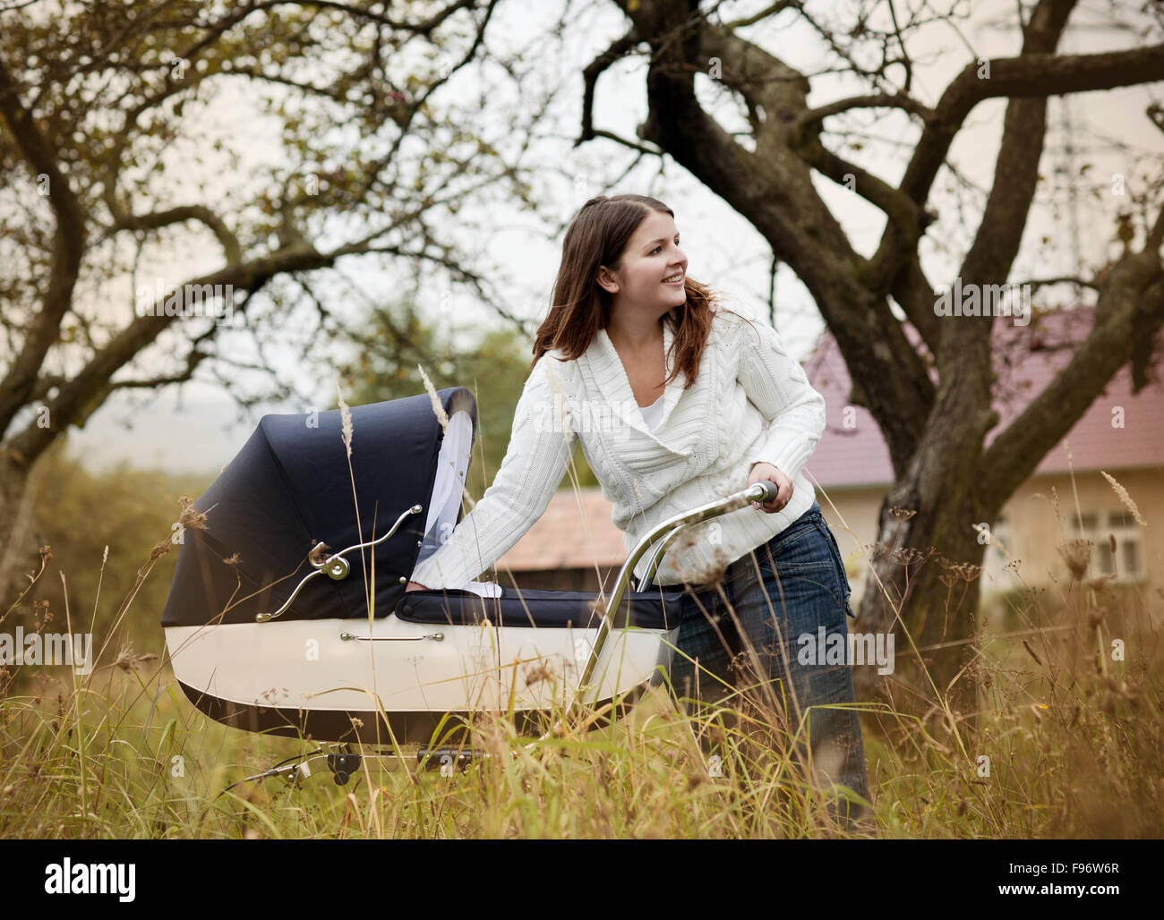 Happy mother with baby in vintage pram relaxing together golden and ...