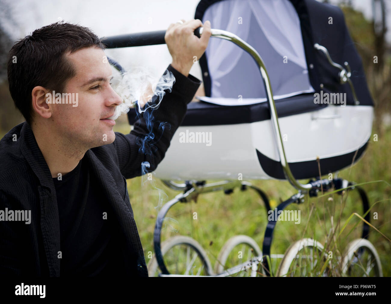 Happy father with baby in vintage pram relaxing together golden and ...