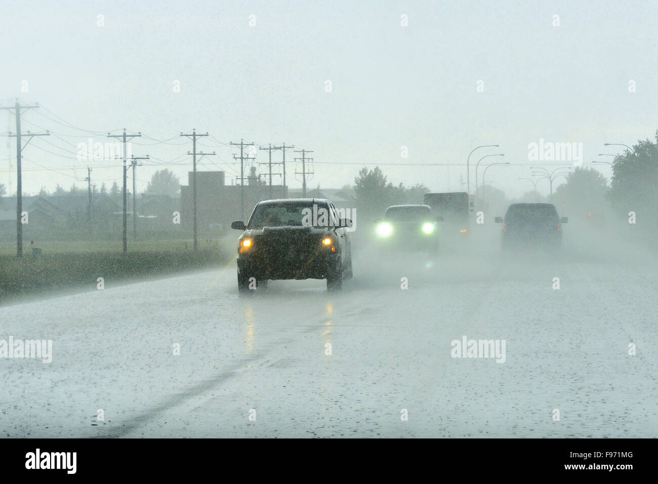 A heavy rain storm slams the roadway making visability very poor ...