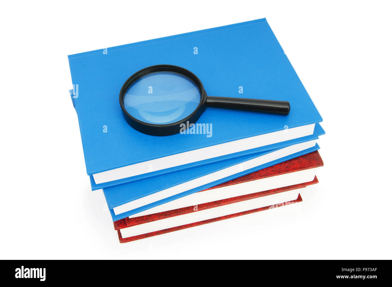 Magnifying glass over the stack of books Stock Photo - Alamy