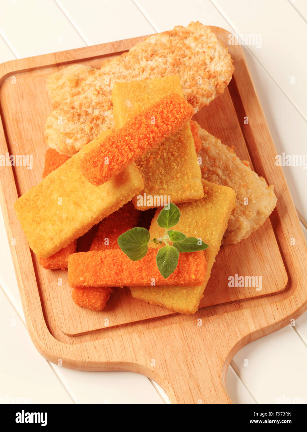 Variety of breaded fish sticks on cutting board Stock Photo - Alamy