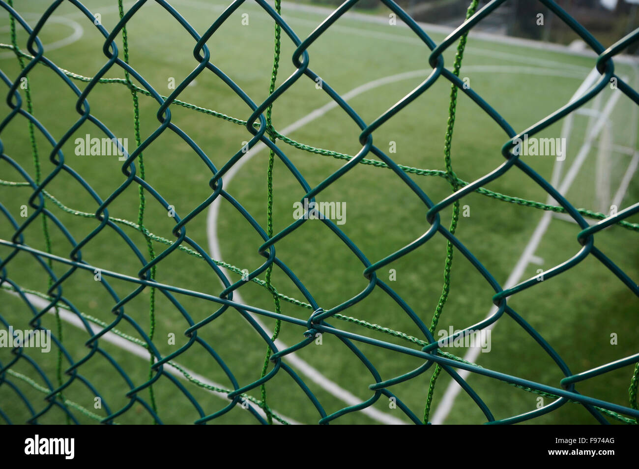 football pitch behind fencing net Stock Photo - Alamy
