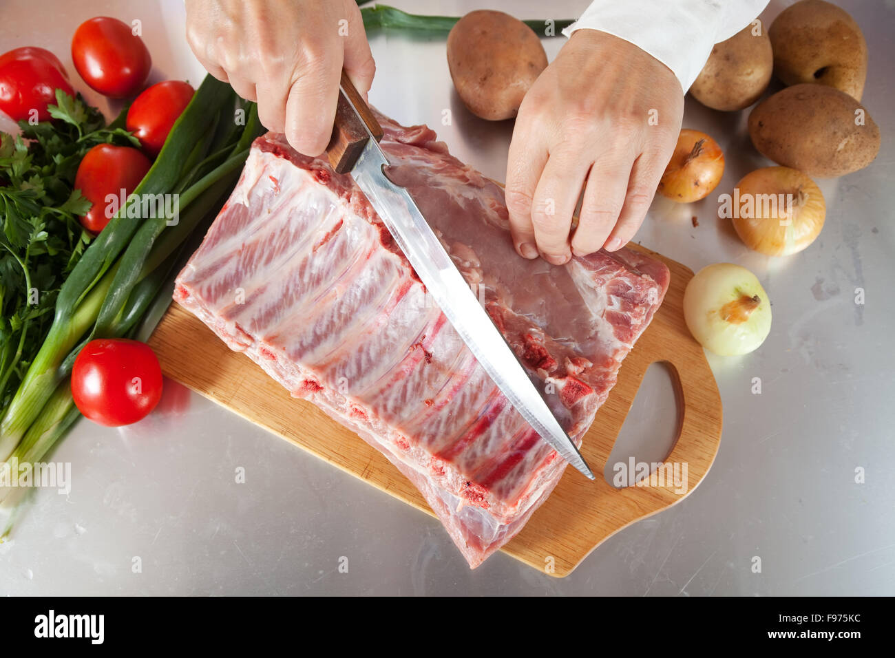 cook hands cutting raw meat at kitchen table Stock Photo - Alamy