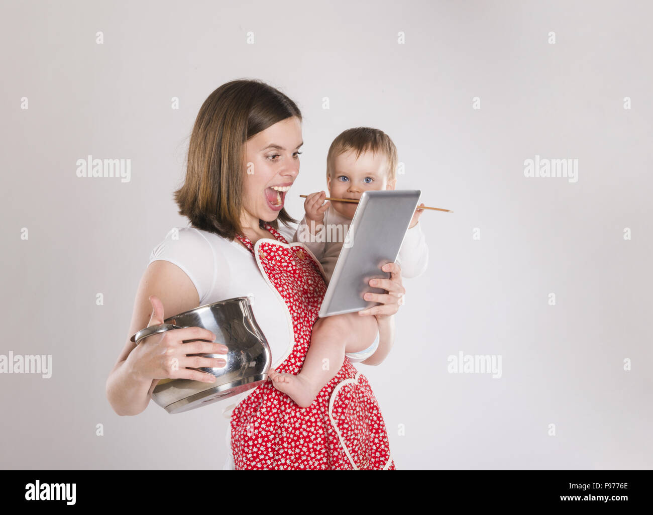 Busy mother and baby with digital tablet Stock Photo - Alamy