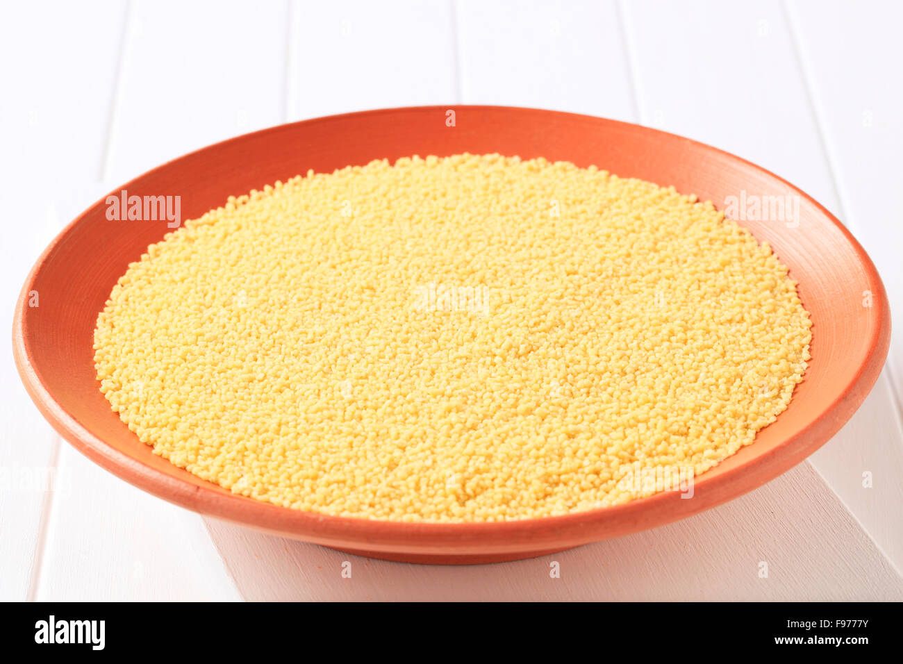 Dried couscous in a terracotta bowl Stock Photo - Alamy