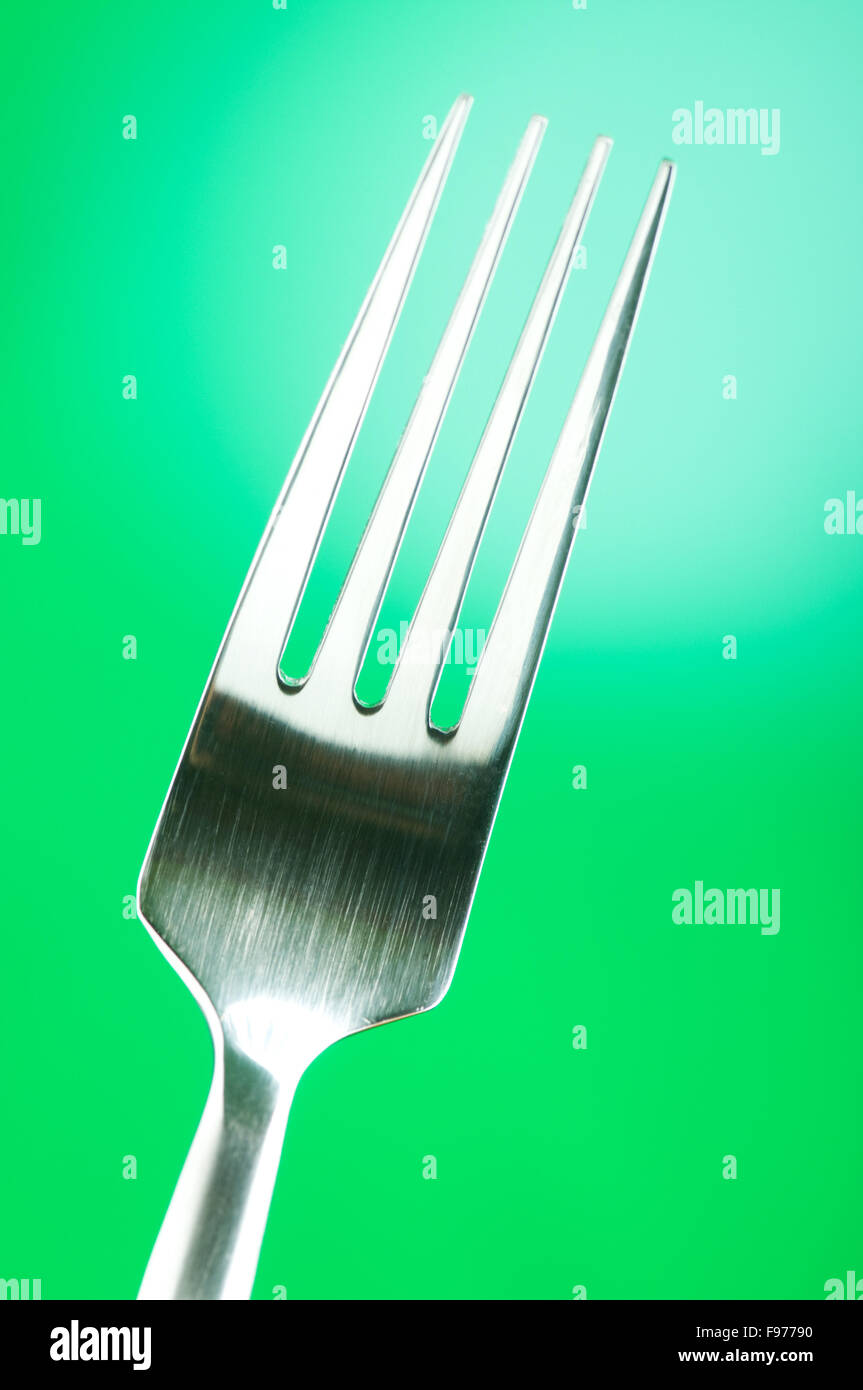 Silver fork against gradient color background Stock Photo - Alamy