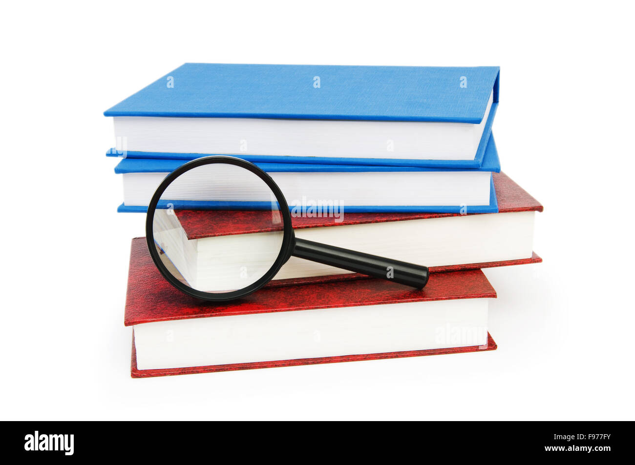 Magnifying glass over the stack of books Stock Photo - Alamy