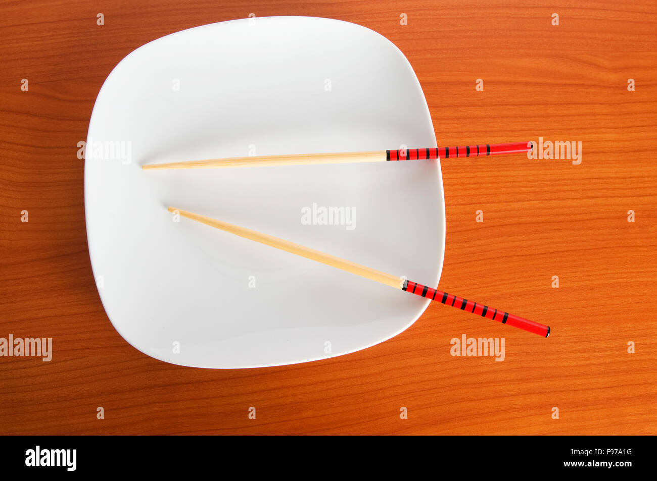 Plate with chopsticks on the wooden table Stock Photo - Alamy