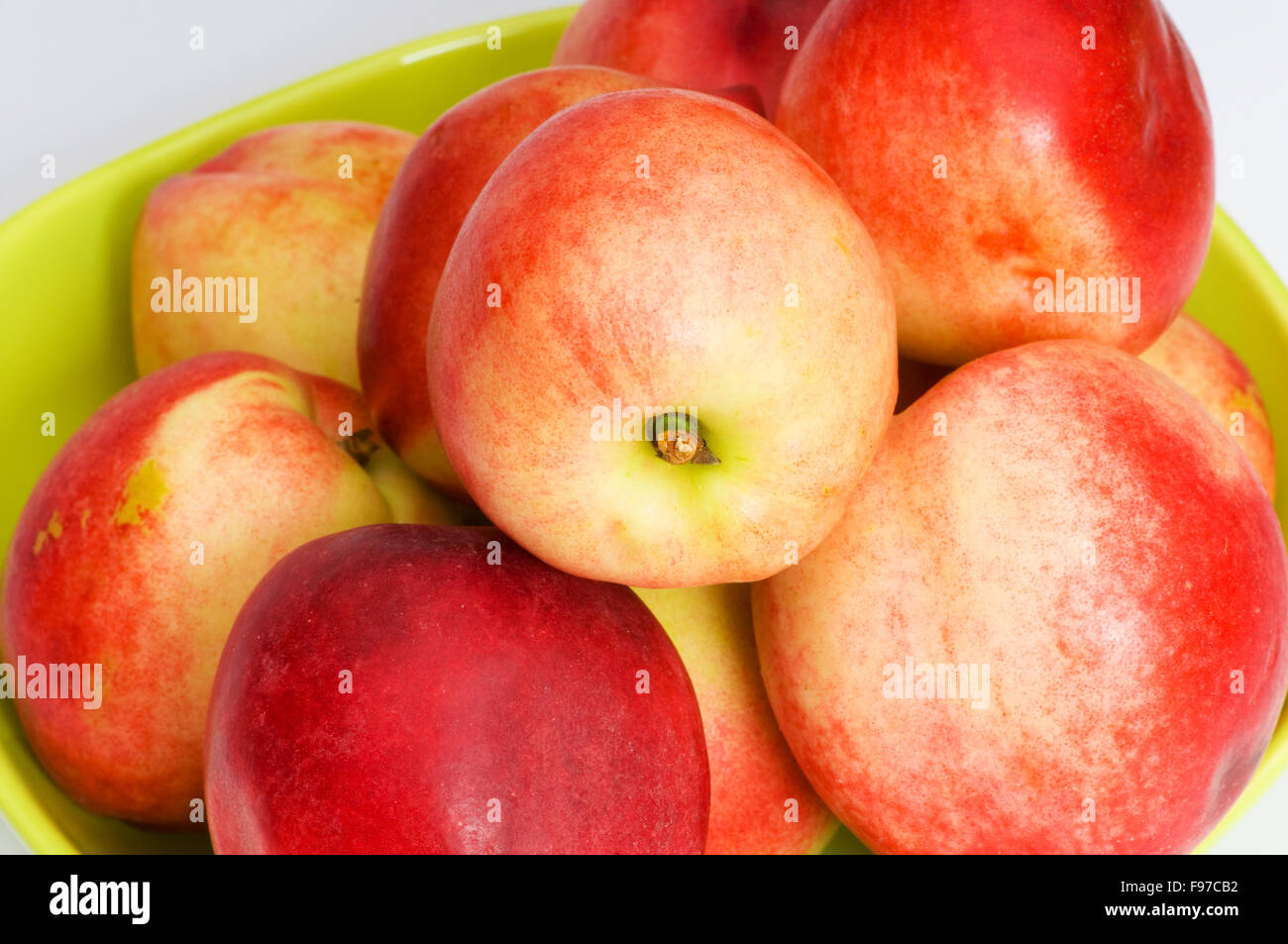 Fresh red nectarines in the green vase Stock Photo - Alamy