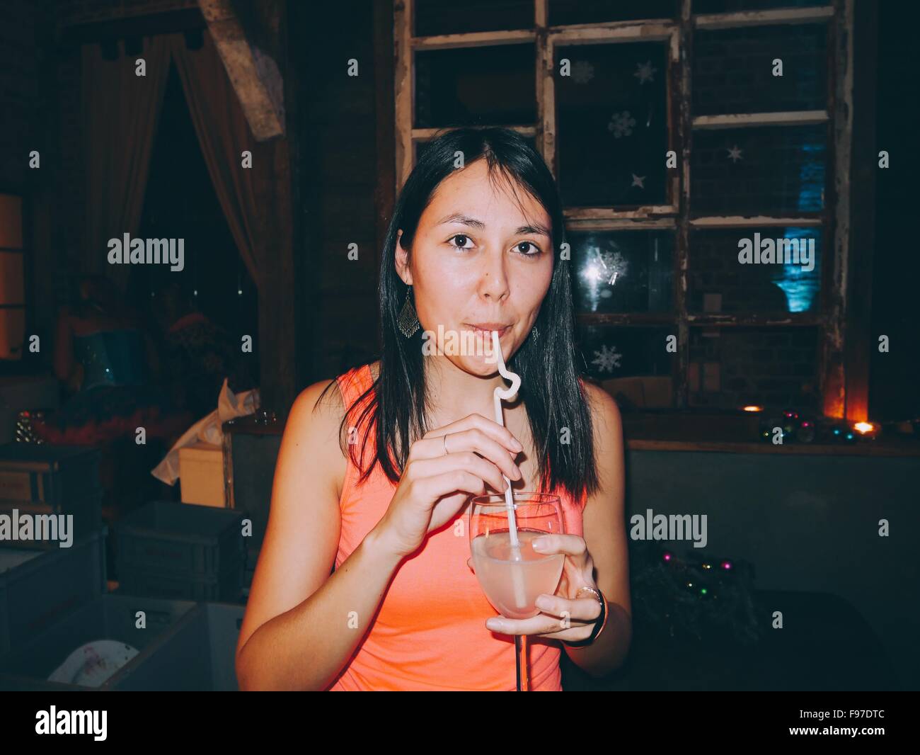 Young Woman Sipping Cocktail Stock Photo - Alamy
