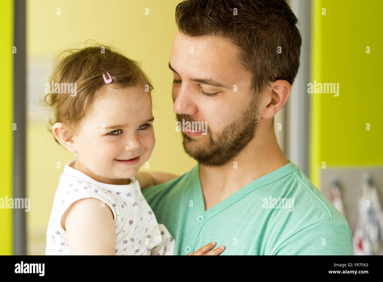 Indoor portrait of young father hugging his little daughter Stock Photo ...