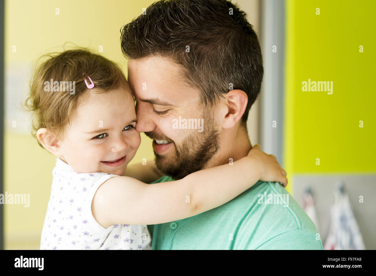 Indoor portrait of young father hugging his little daughter Stock Photo ...