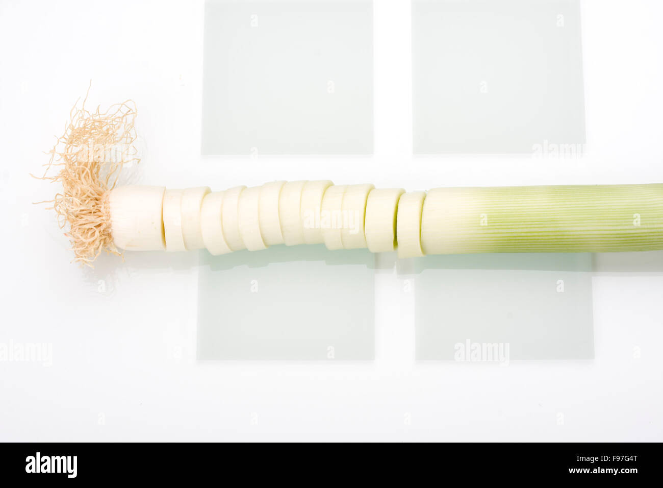 slices of leek on a glass chopping board Stock Photo - Alamy